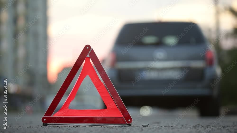 Red emergency stop sign behind broken blurred car with blinking lights ...