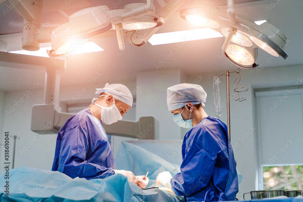 Spinal surgery. Group of surgeons in operating room with surgery ...