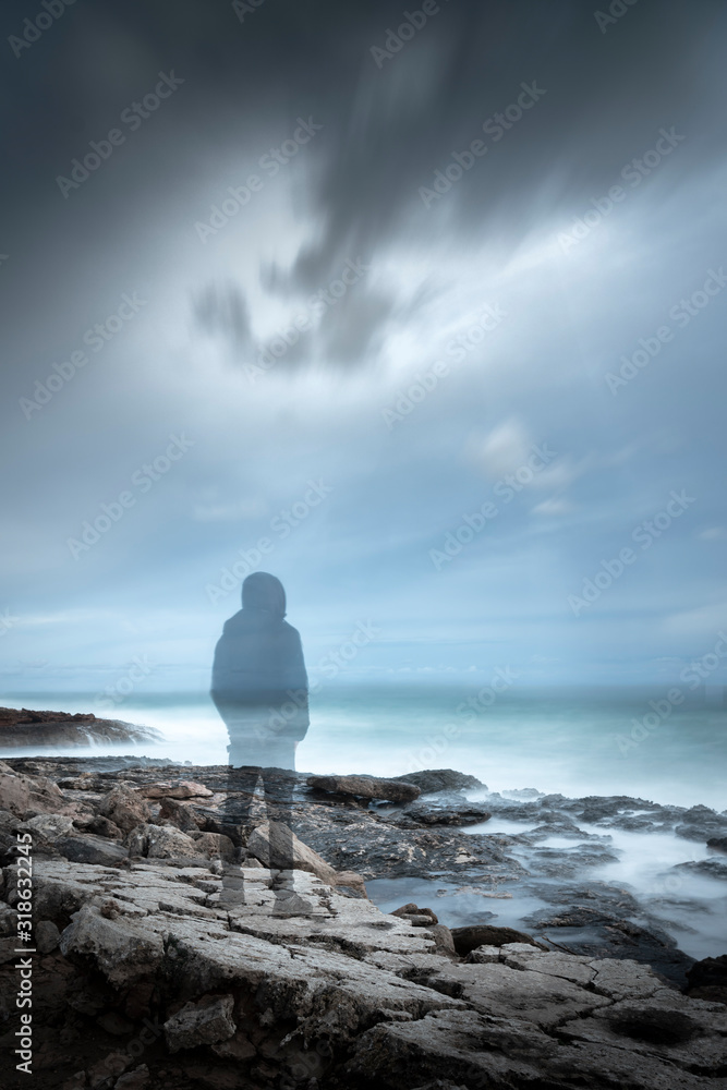 Transparent gloomy scene of a hooded man like a ghost, dressed in black ...
