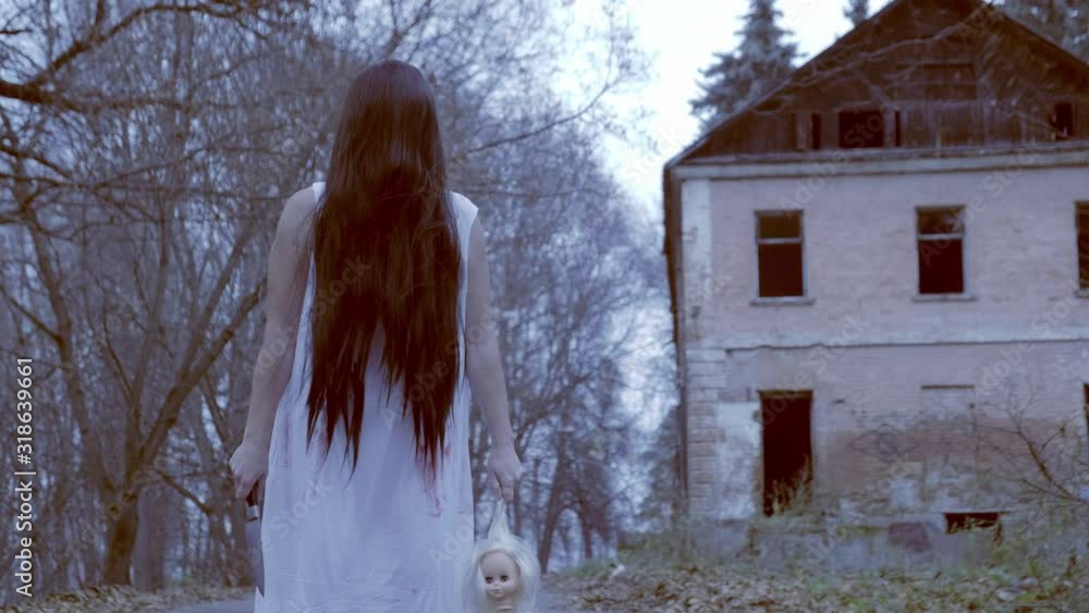 Mystical girl with black long hair on background of ominous house ...