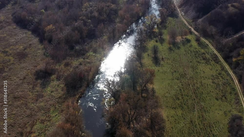 Aerial shot of the Oskol river and many trees in warm sunny weather in ...