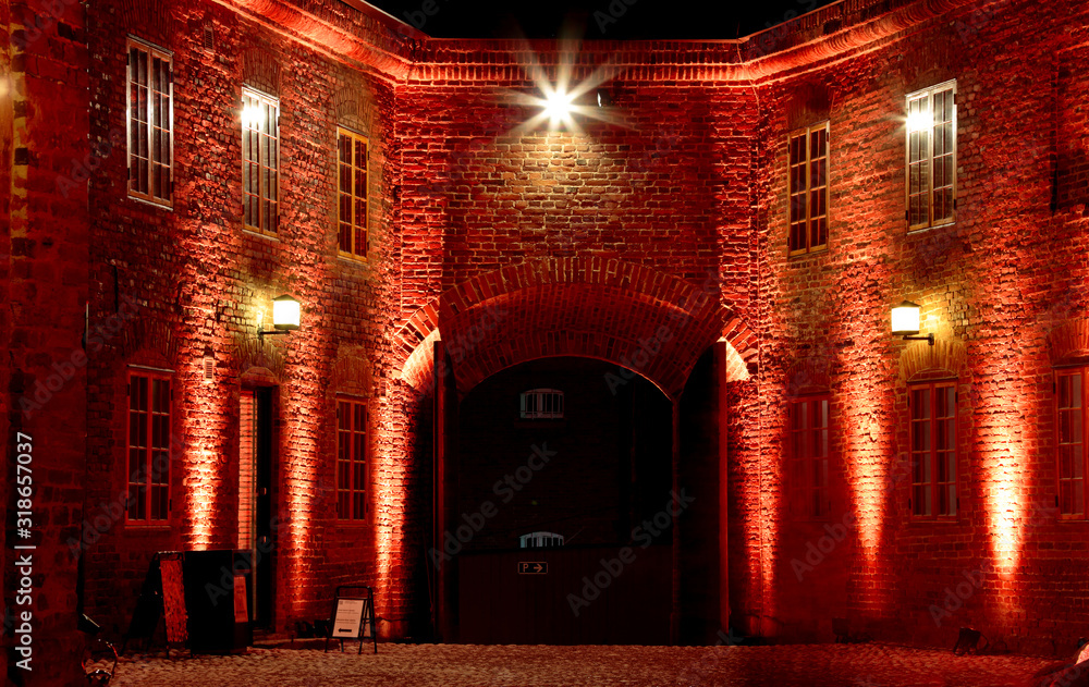 The entrance of a medieval castle in Finland. Red lightning shows the ...