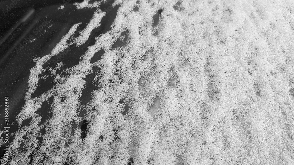 Abstract background. Snowy texture on smooth dark glass window ...
