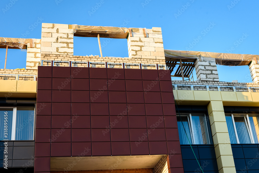Installing big tile on a building facade. Stock Photo | Adobe Stock
