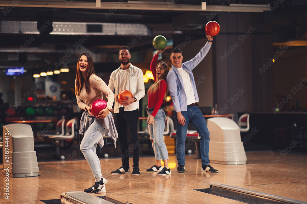 Beautiful group of young people posing in a bowling alley with a ball ...
