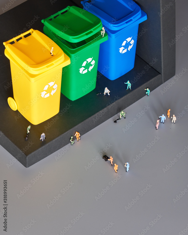 Miniature people, workers around three color coded recycle bins ...