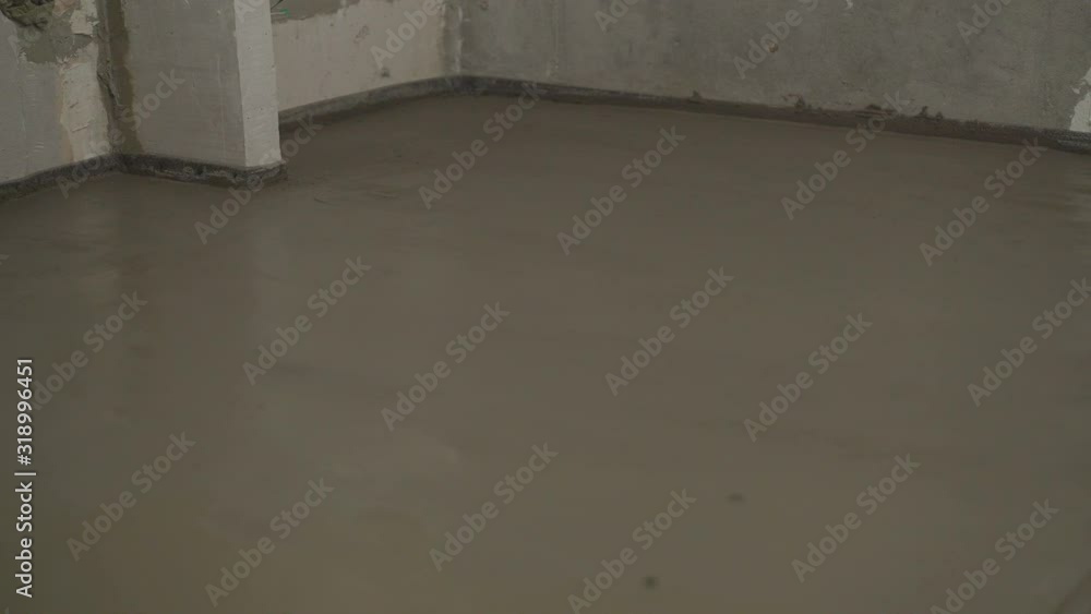 Leveling the floor with a long spatula. Builder levels a laid floor ...