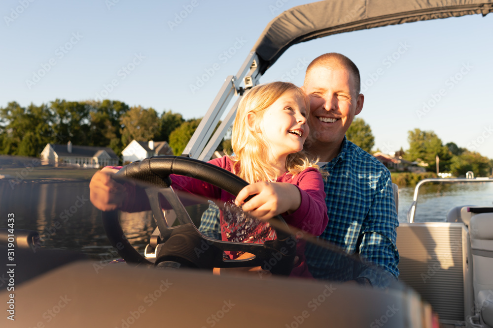 You girl driving a boat with her father during summer Stock Photo ...