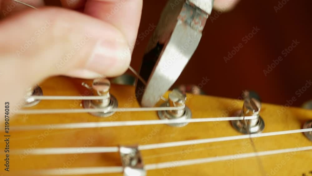 Cutting off the excess guitar string. Changing electric guitar string ...