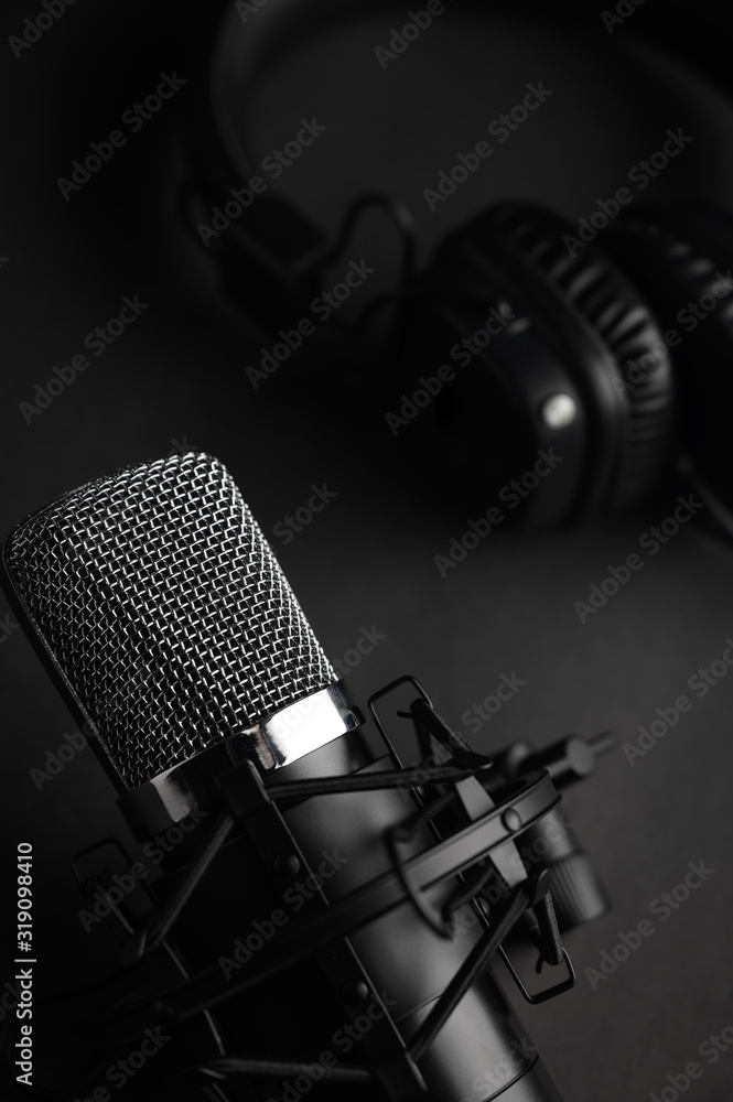 Microphone for podcasts and studio headphones on a black background ...