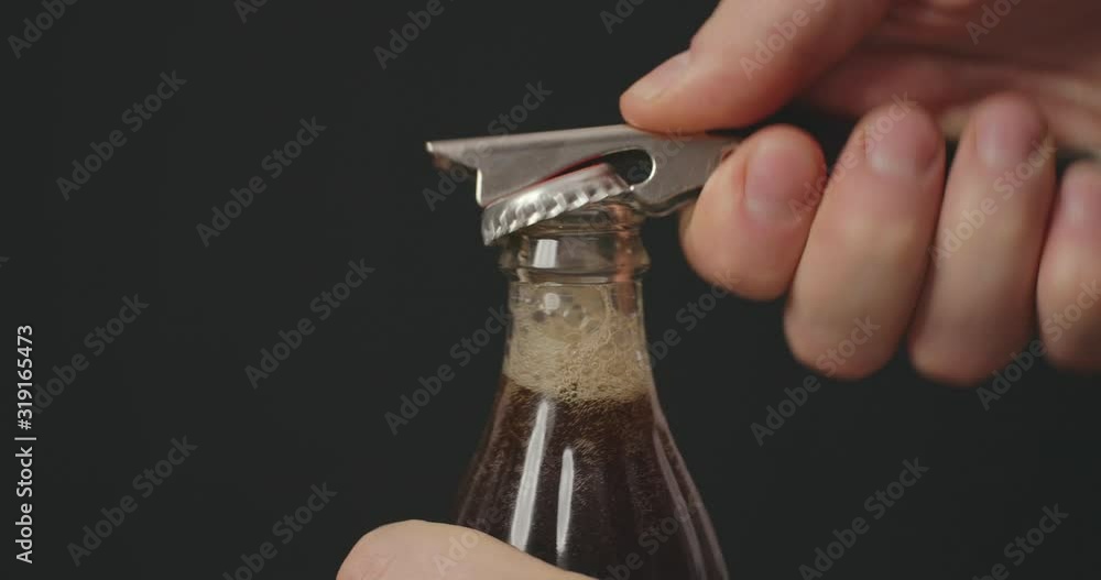 Soda glass bottle being opened by opener. Man's hands open fizzing ...