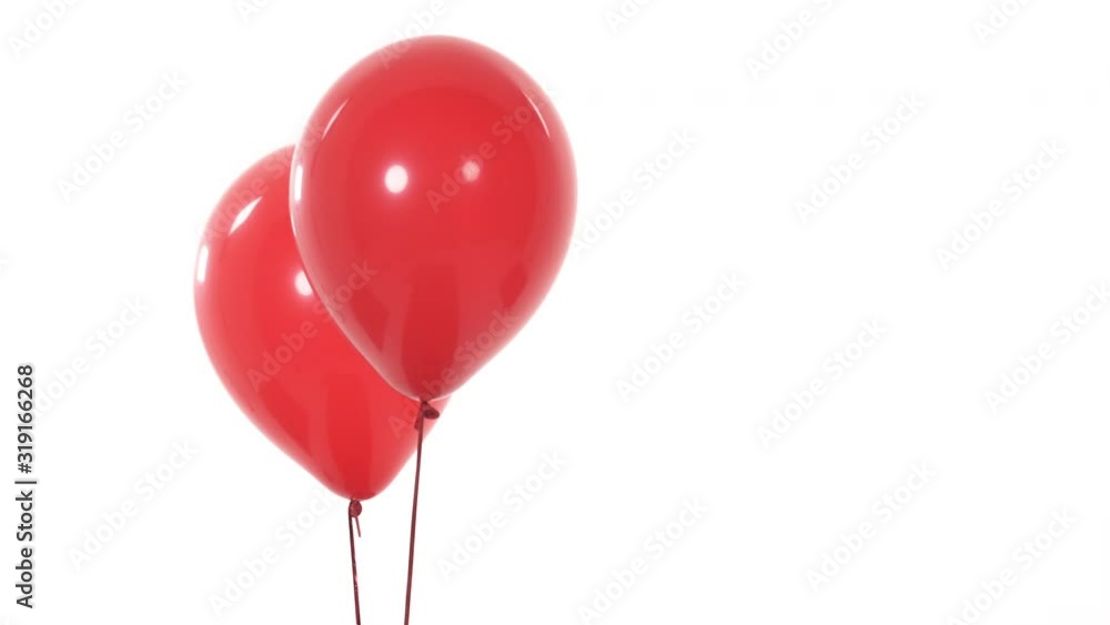 Close-up of two red flying balloons. Objects moving from left to right ...