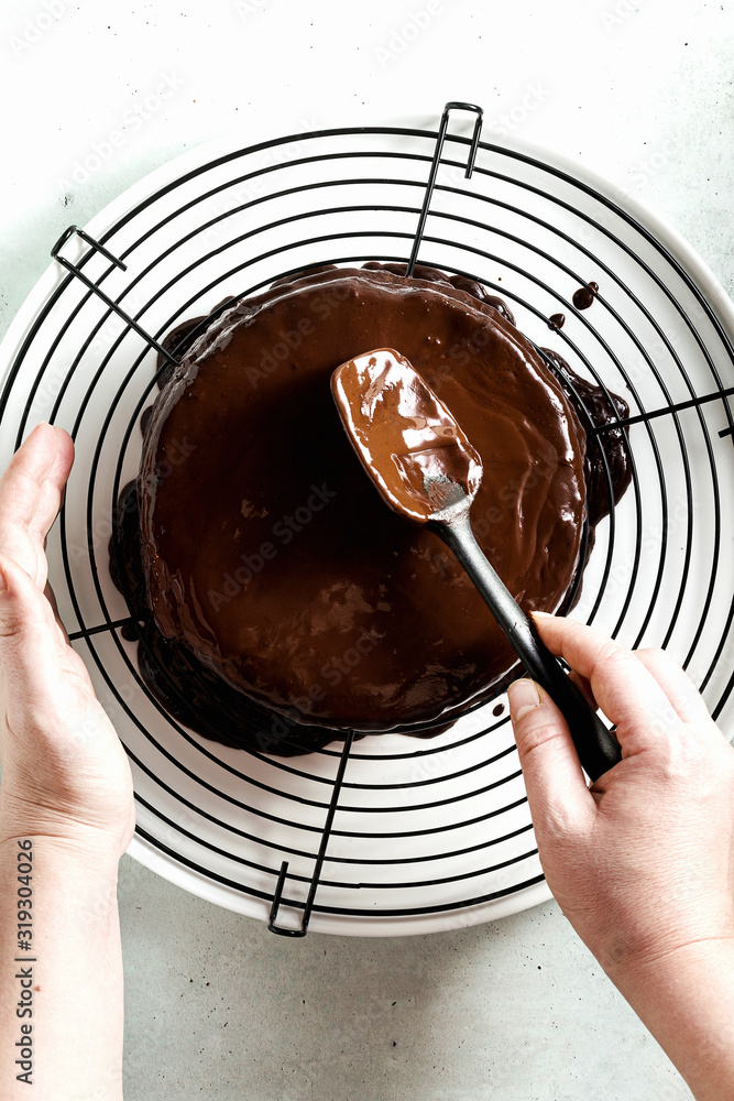 pouring chocolate ganache on the cake. female hands Stock Photo | Adobe ...