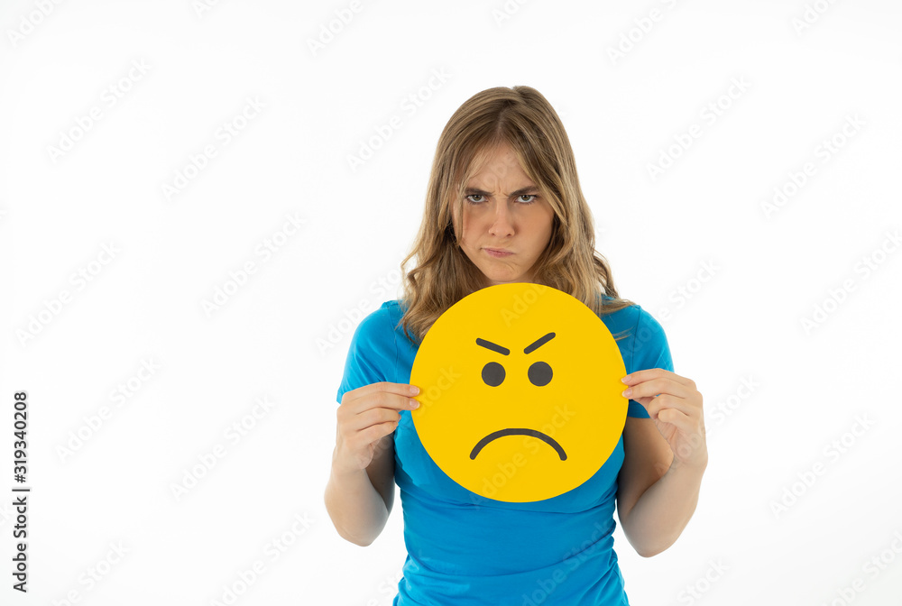 Beautiful young woman holding angry face emoji in social media ...