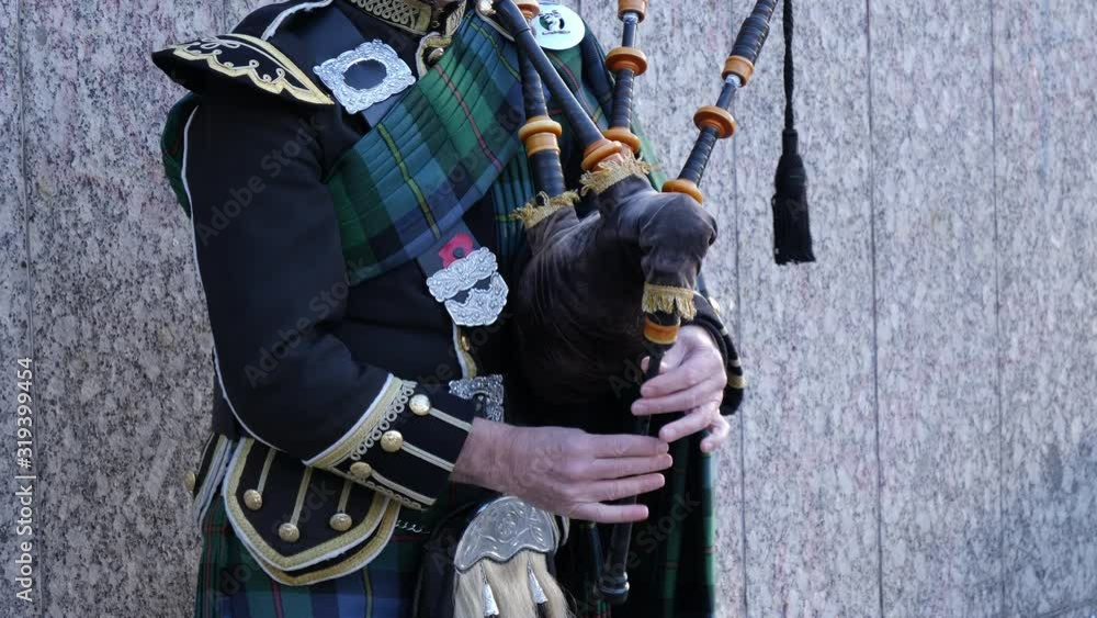 Bagpiper in Scotland wearing traditional tartan kilts playing the pipes ...