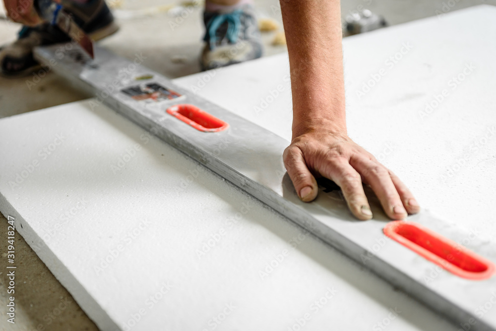 Worker mark the correct length and dimension of styrofoam on ...