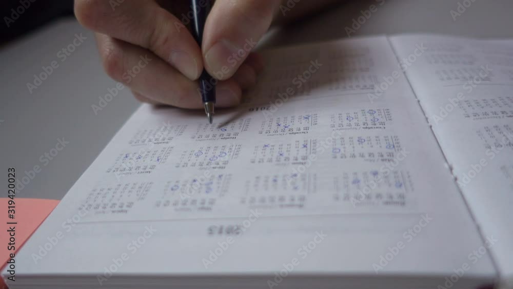 A man makes a date stamp in the calendar diary. Workflow planning ...