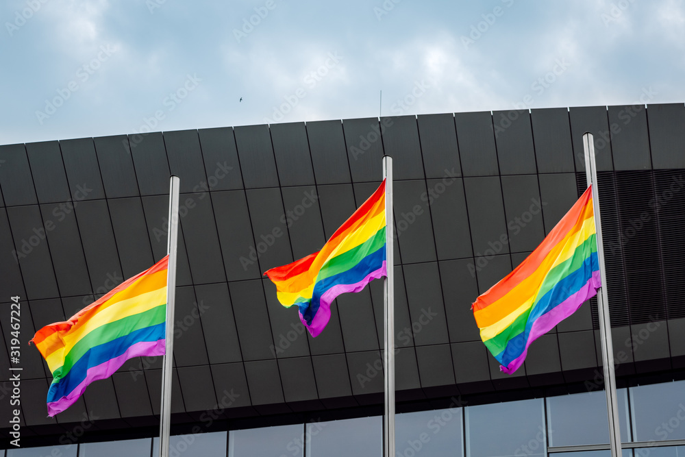 Three colorful rainbow, gay, pride flags blown by the wind. The rainbow ...