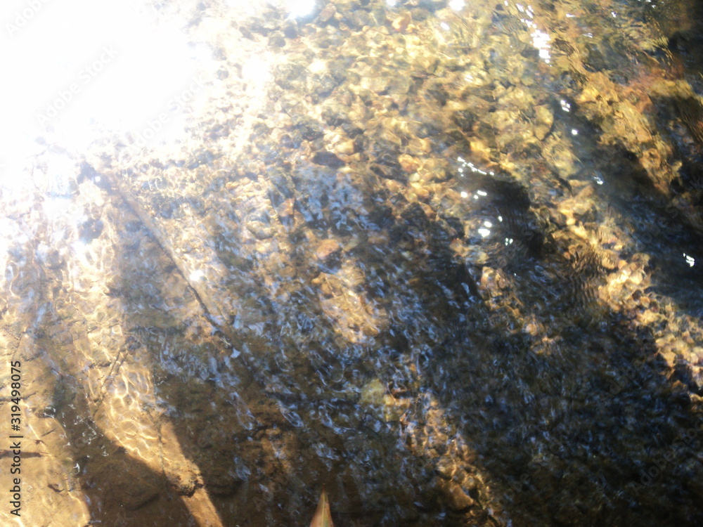 Ripples in the river flow through the rocks, colorful in the summer in ...