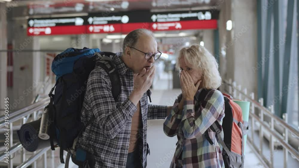 Unhealthy senior tourists sneezing and coughing in public place of ...