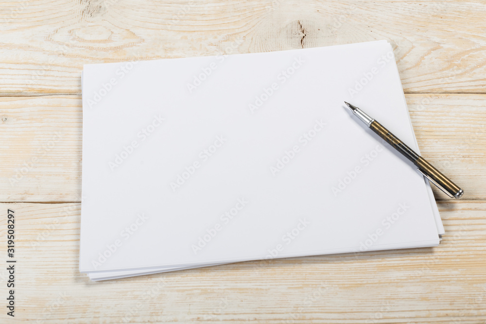 A4 white paper with pen on wooden background. Blank branding template ...
