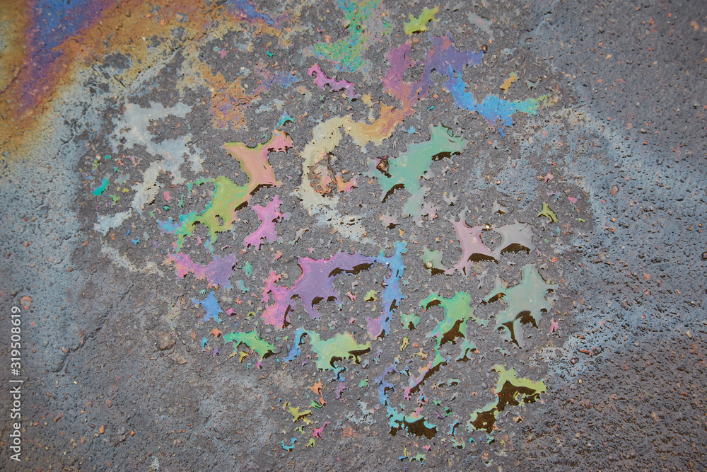 Colored oil stains on the asphalt, the color of the gasoline stain on ...