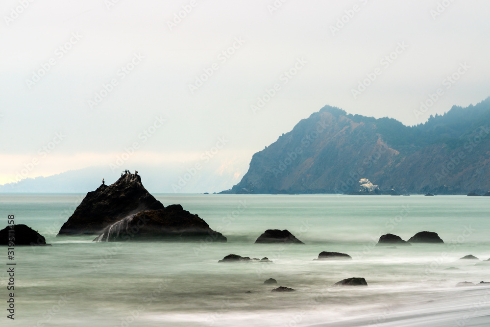 Looking north along the coast during a foggy sunset at Wheeler Beach ...