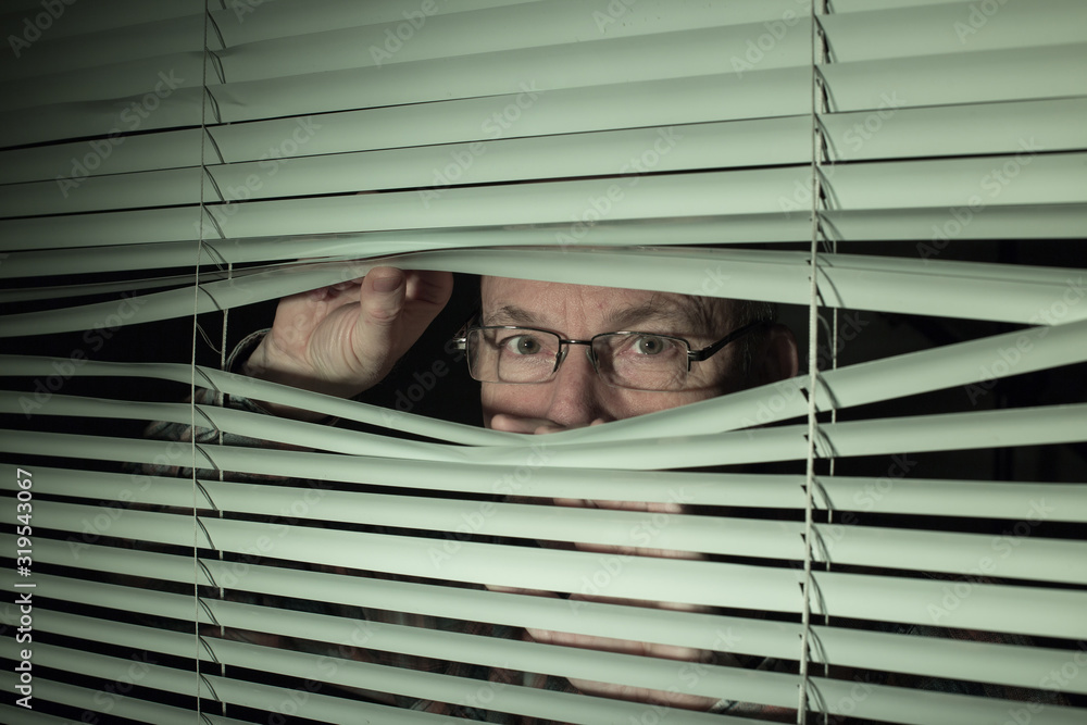 Man peeking through blinds Stock Photo | Adobe Stock
