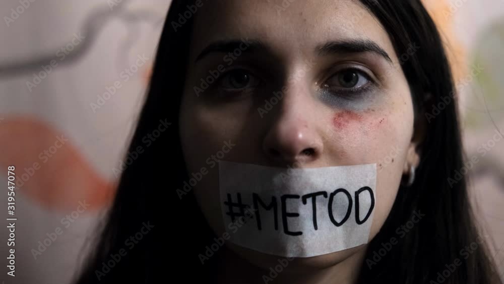 A young female victim of violence raises her head and shows the word ...