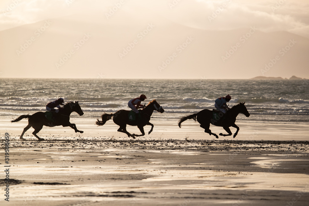 Race horses and jockeys racing on the beach, wild Atlantic way on west ...