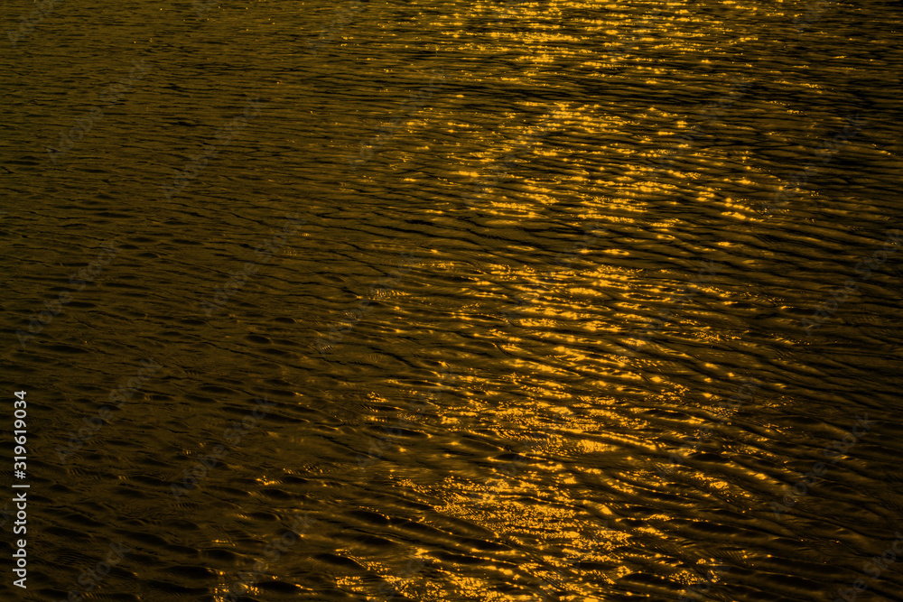 Rippling gold water surface in swimming pool, water river for ...
