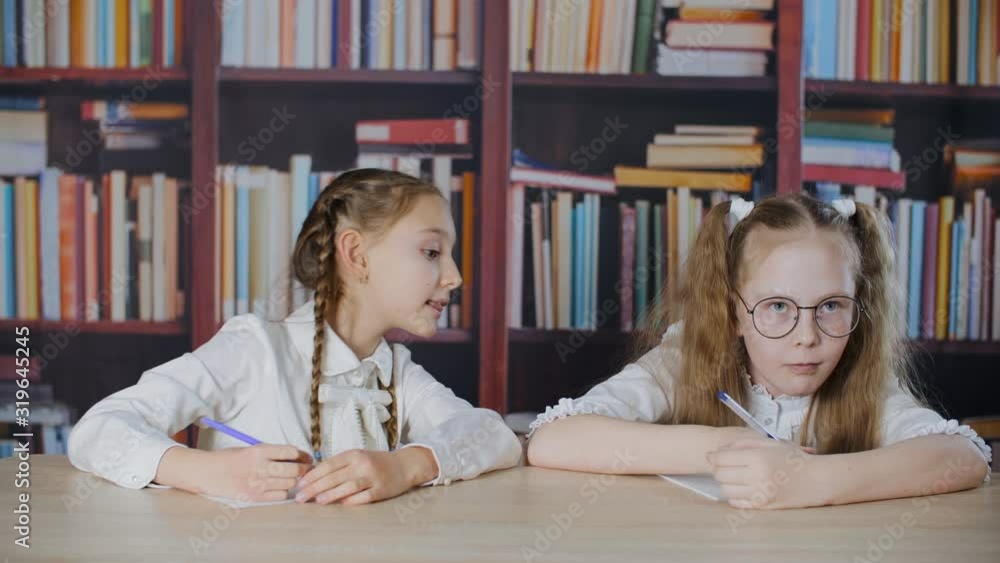 Schoolgirl copying solution from classmate at exam in school on ...