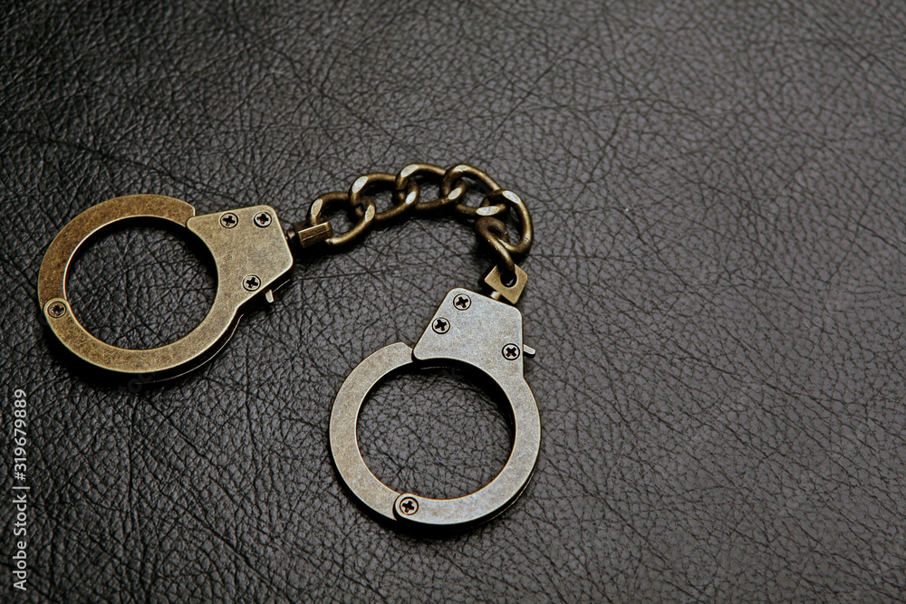 iron handcuffs dark leather background Stock Photo | Adobe Stock