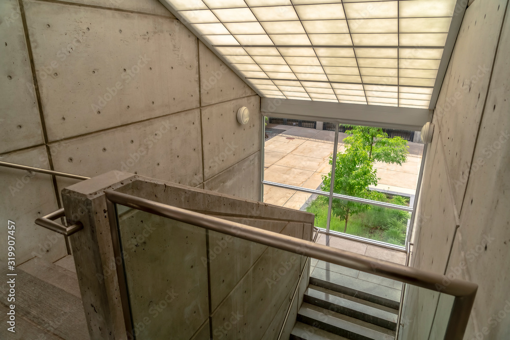Flight of stairs of a building with metal handrails and slanted glass ...