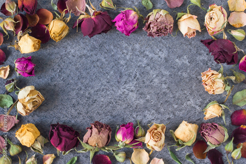 Frame of laid out dry buds of roses, petals, leaves on a dark ...