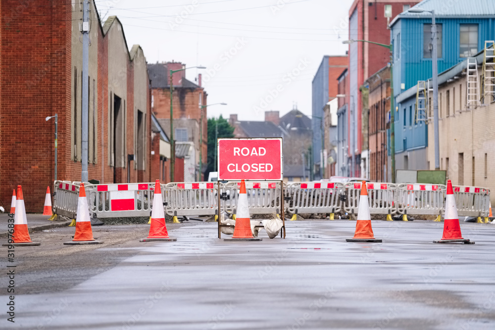 Road ahead closed sign with traffic cones and red barrier fence ...