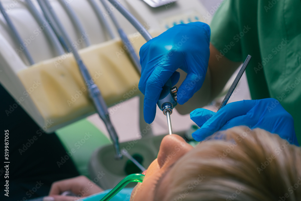 Female dentist with rubber gloves checking up the teeth of her patient ...