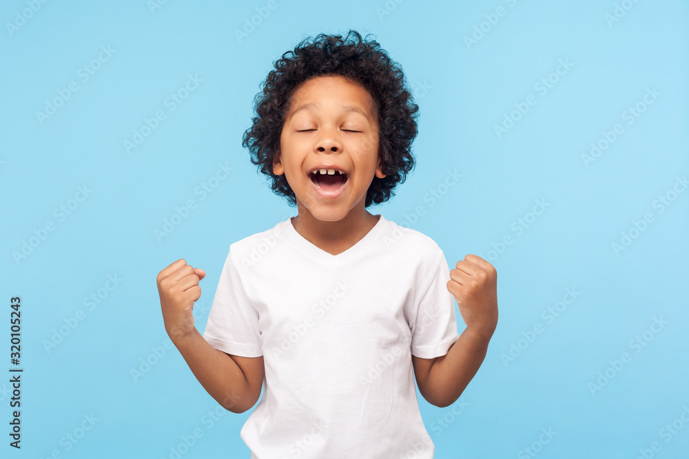 Child winning, success. Portrait of excited little boy in T-shirt ...