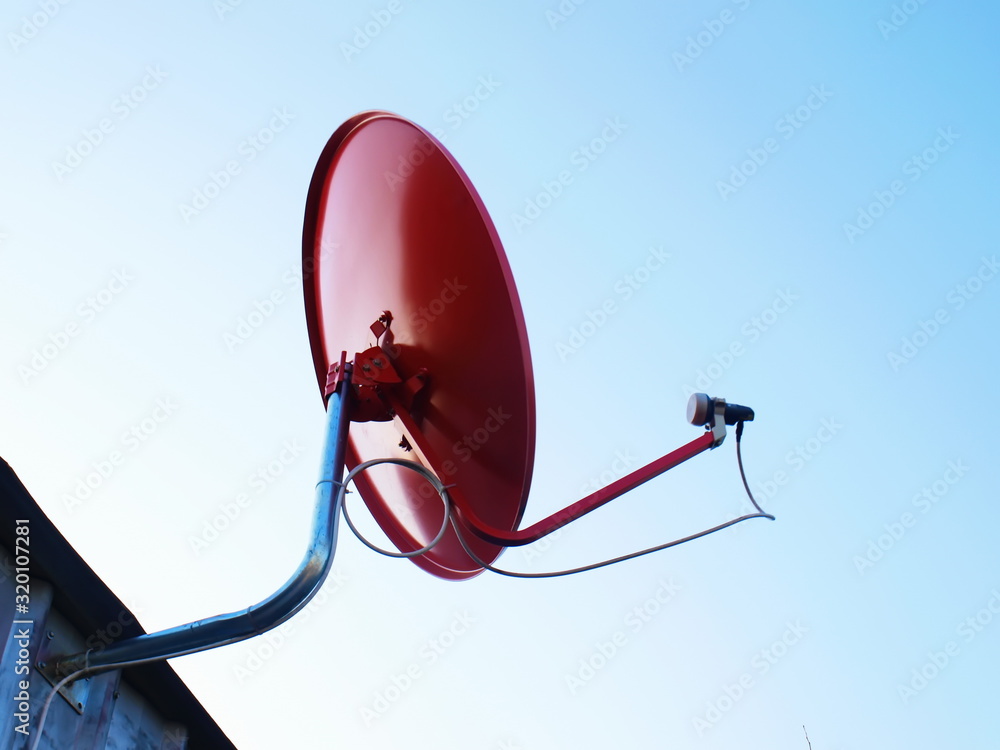Red television receiver on the roof Digital satellite dish or receiver ...