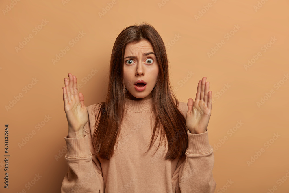 Impressed stupefied European woman shows something very big or huge ...