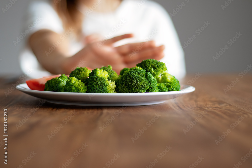 No vegan diet concept. Teen girl pushing away plate with broccoli and ...