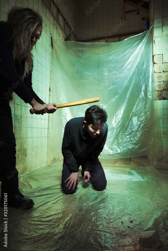 Evil kidnapper beating victim with baseball bat on plastic foil Stock ...