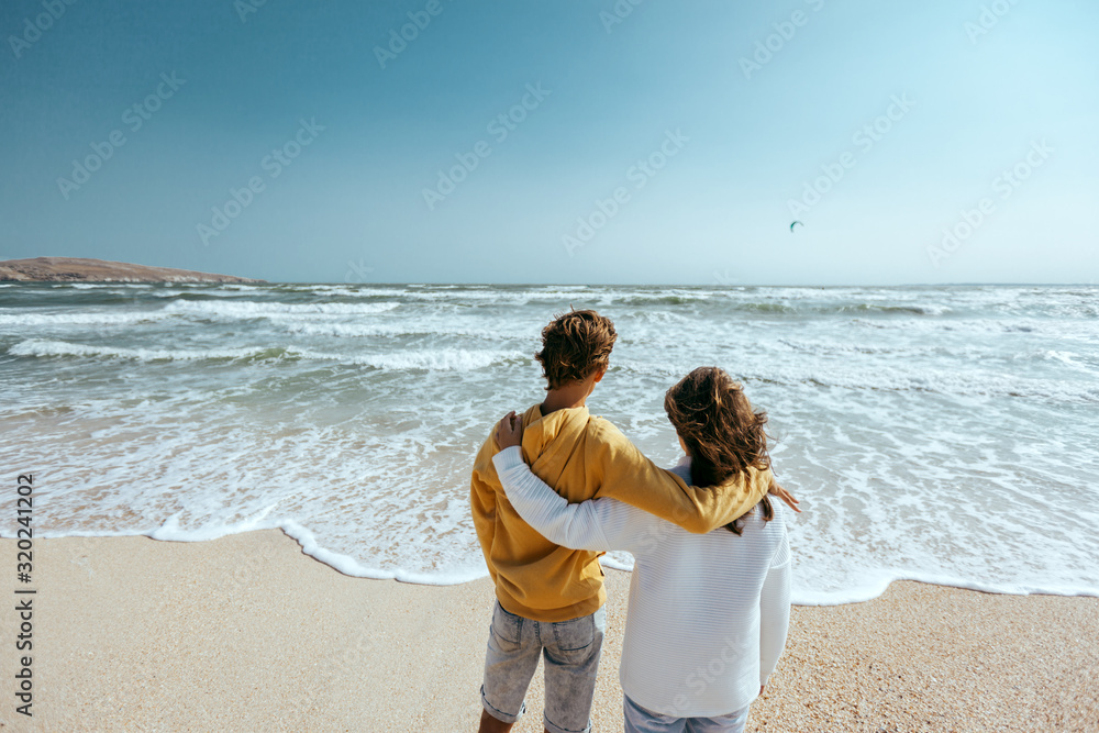 Back view of teenage boy and girl hugging and wathing the sea. Stock ...