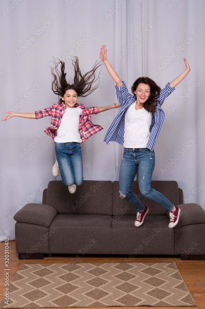Fun leisure at home. girls party at home. happy sisters jump in freedom ...