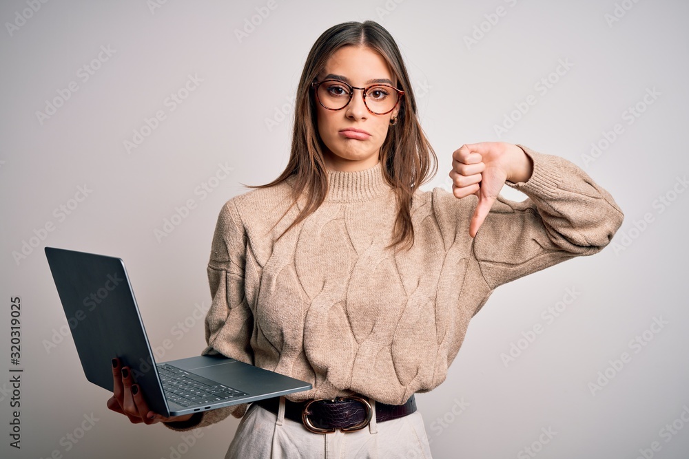 Young beautiful brunette woman working using laptop over isolated white ...