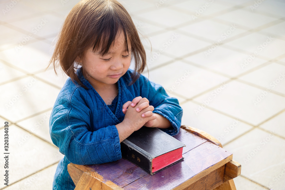 Little cute girl with Chinese Bible kneeling and praying Stock Photo ...
