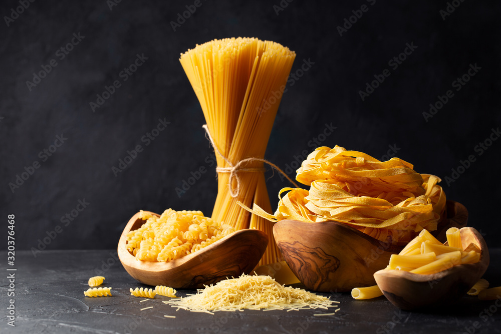 Variety of types and shapes of Italian dry pasta on black background ...