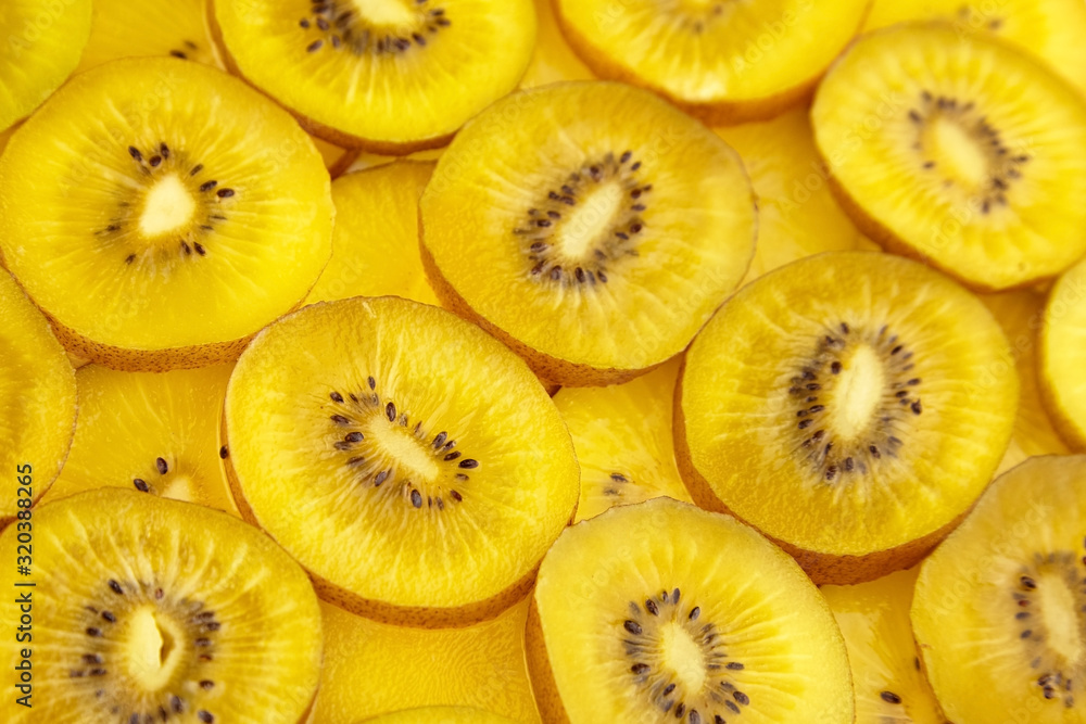 Kiwi Gold fruit background. Yellow kiwi slices with black seeds ...