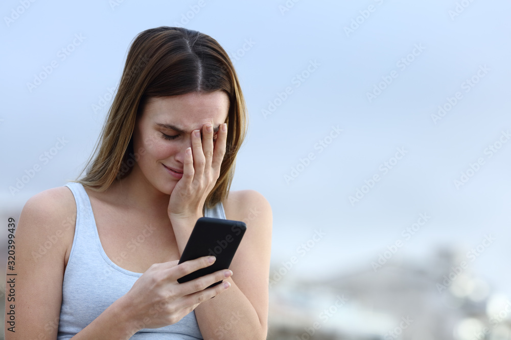 Sad woman crying checking mobile phone Stock Photo | Adobe Stock
