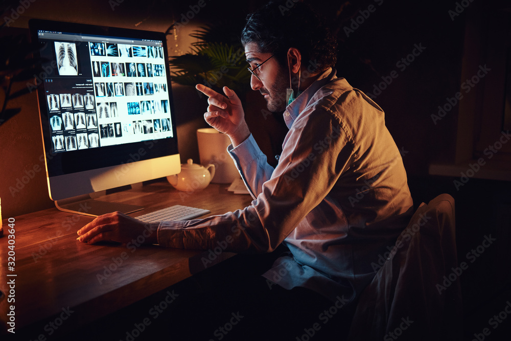 Smart medic in glasses is working with x-ray screens using a computer ...